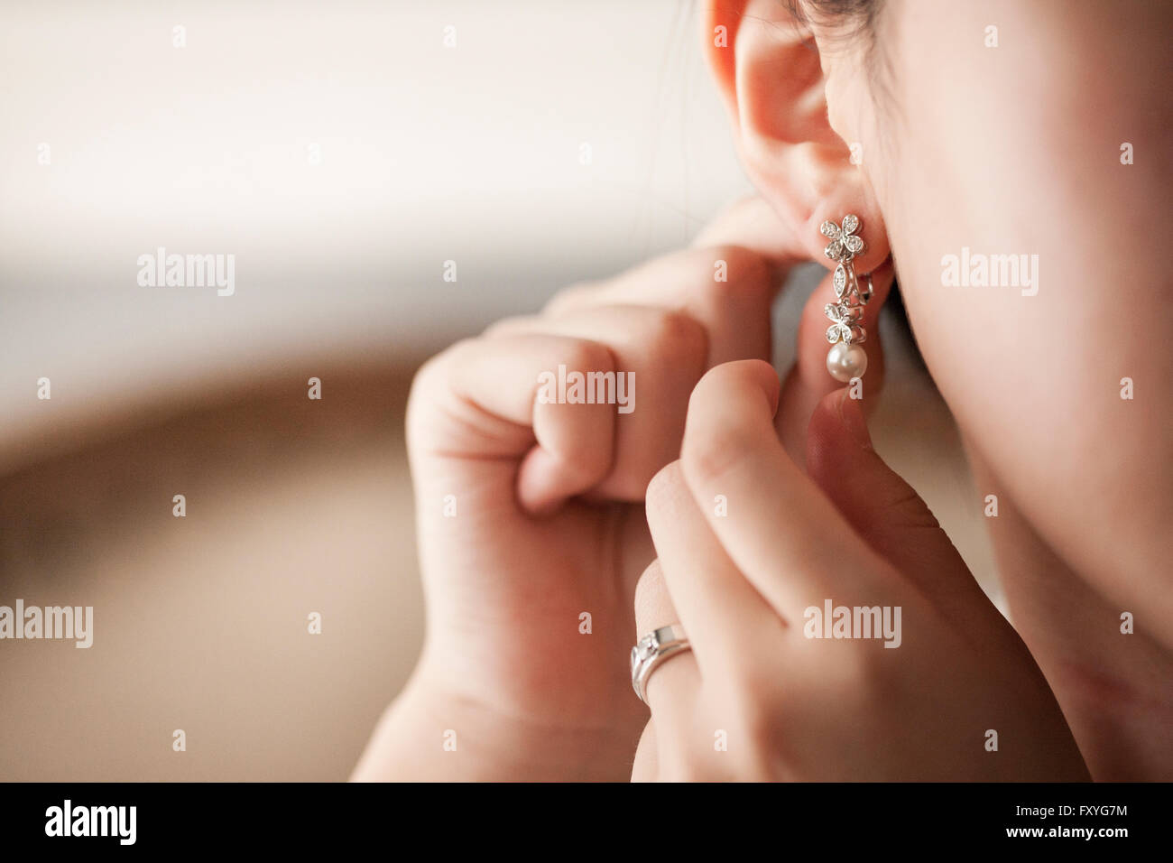 Earring being put on by a bride Stock Photo - Alamy