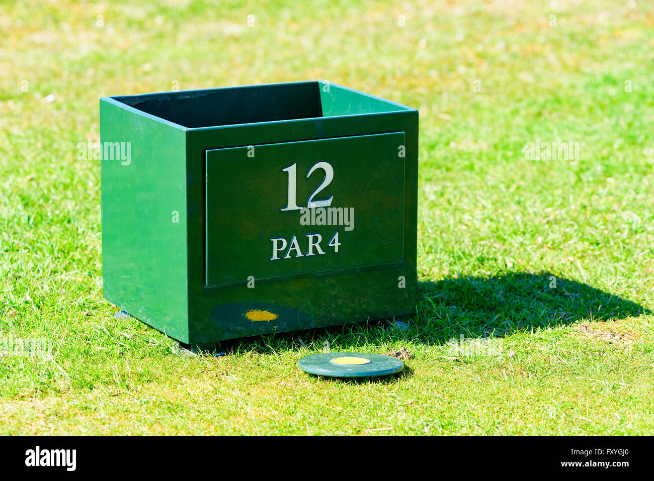Circular marker lying on tee on a golf course. Nicely cut grass ...