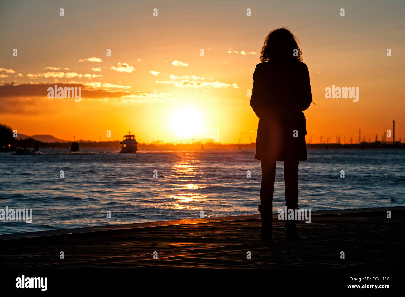 Woman watching the sunset on the Zattere promenade, Venice, Italy Stock ...