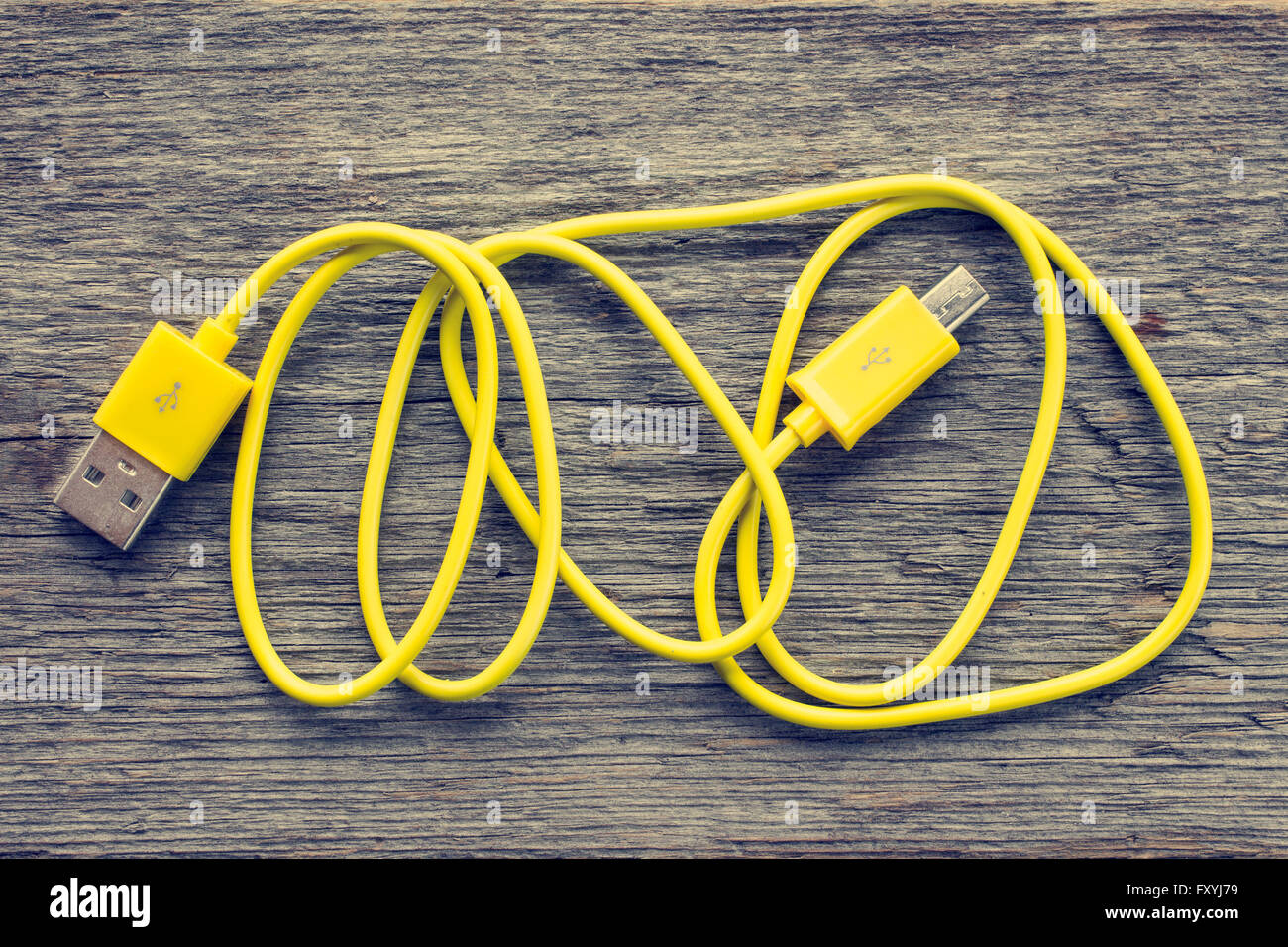 Yellow USB cable on wooden table - top view Stock Photo - Alamy
