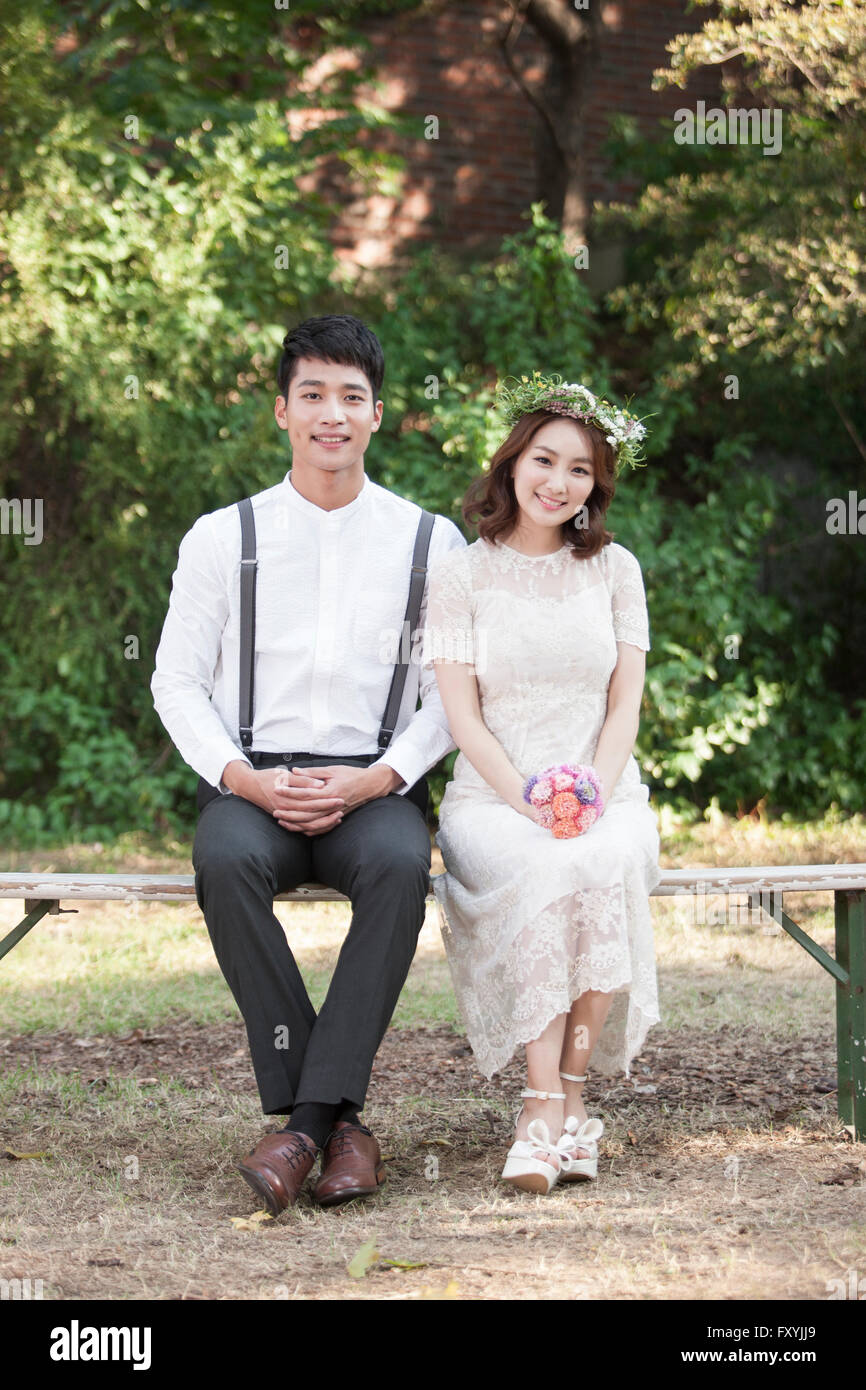 Bride and bridegroom together outside seated on a bench Stock Photo - Alamy