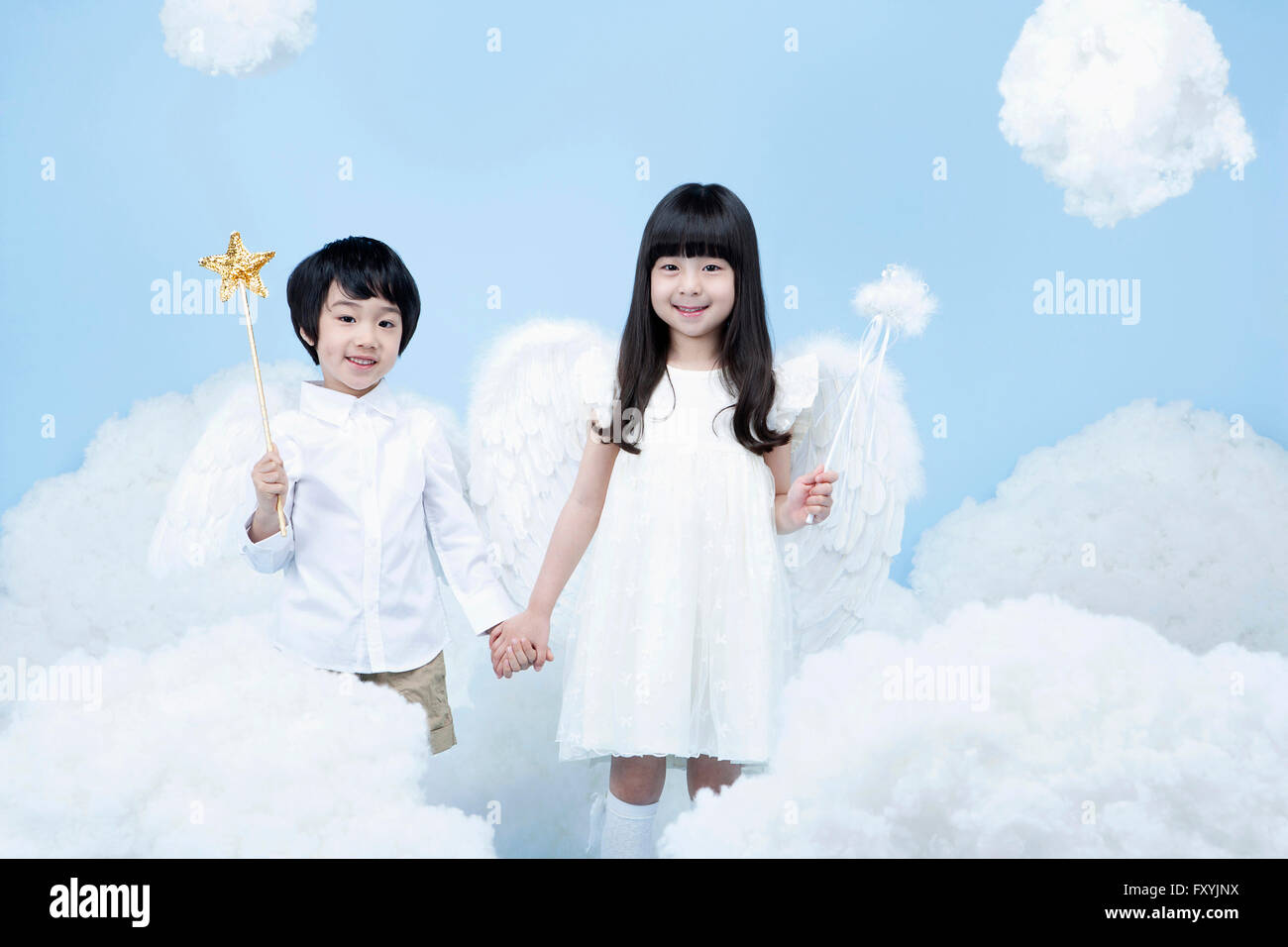 Boy and a girl holding a magic stick each in the background ...