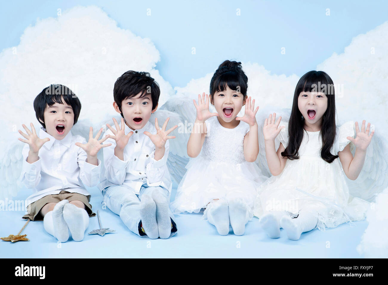 Four children in angel costume seated together in surprise in the ...