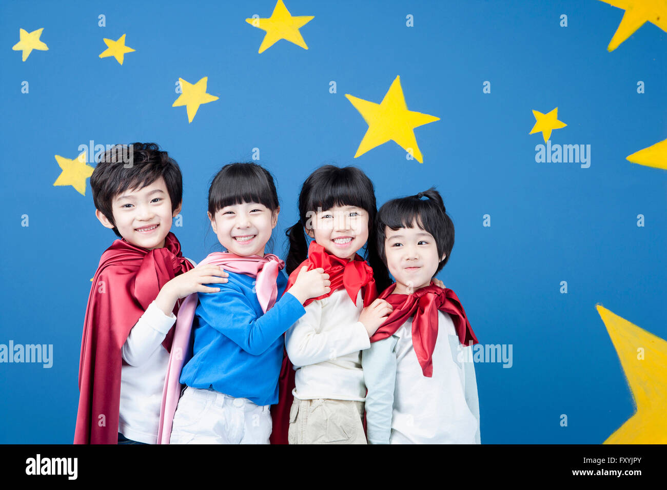 Four children in red cape lined up staring forward with a smile Stock ...