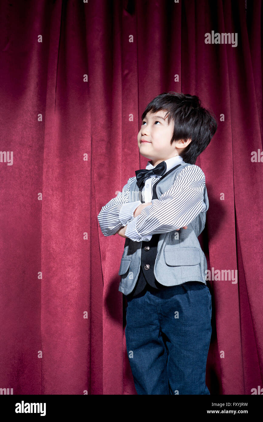 Boy standing with his arms folded looking up on the stage Stock Photo ...