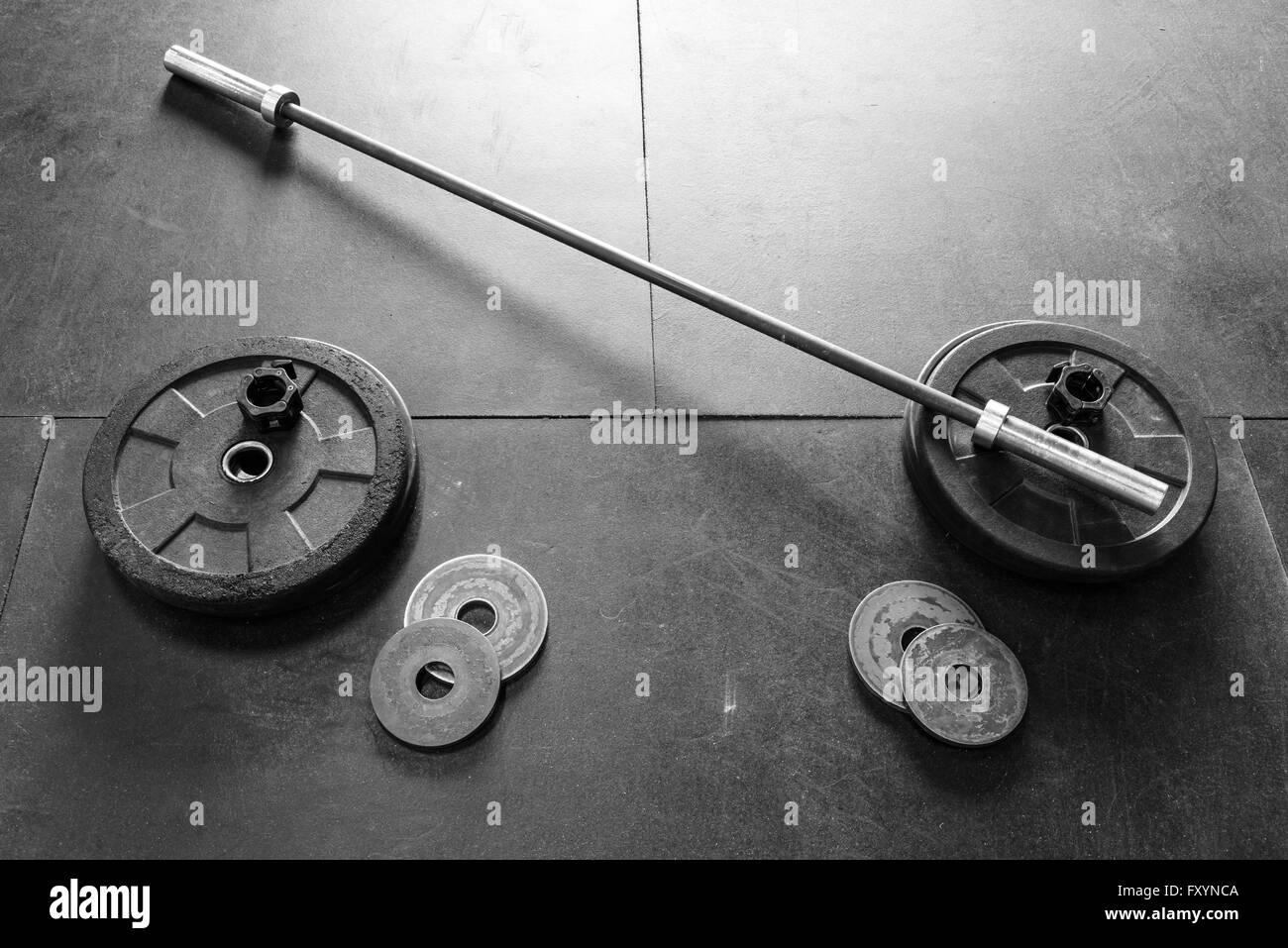 Barbell and weights on a gym floor, in black and white Stock Photo - Alamy