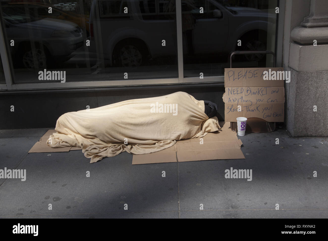 Homeless person sleeps on the sidewalk in midtown Manhattan as people ...