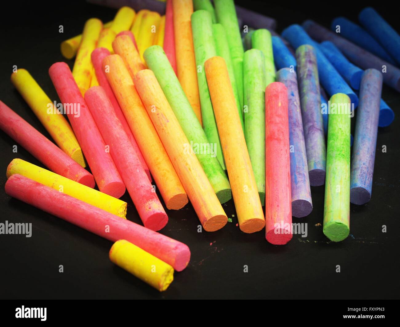 Colored chalk on a blackboard background Stock Photo - Alamy