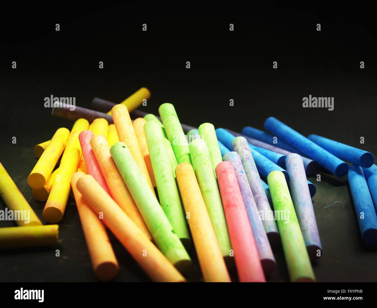 Colored chalk on a blackboard background Stock Photo - Alamy