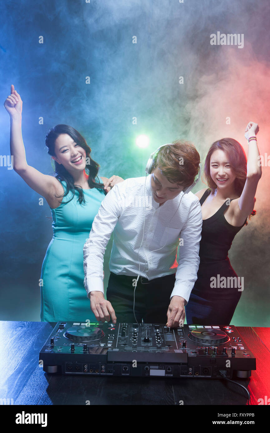 Two young smiling women dancing with DJ at nightclub Stock Photo - Alamy