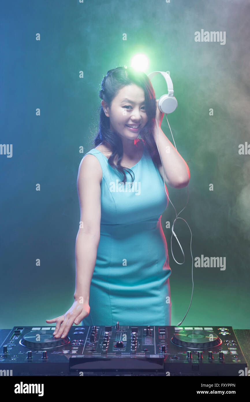 Young smiling female DJ staring at front at nightclub Stock Photo - Alamy