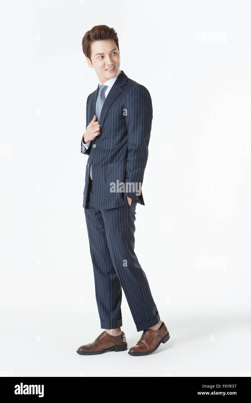 Side view of young smiling man in suit standing looking back Stock ...