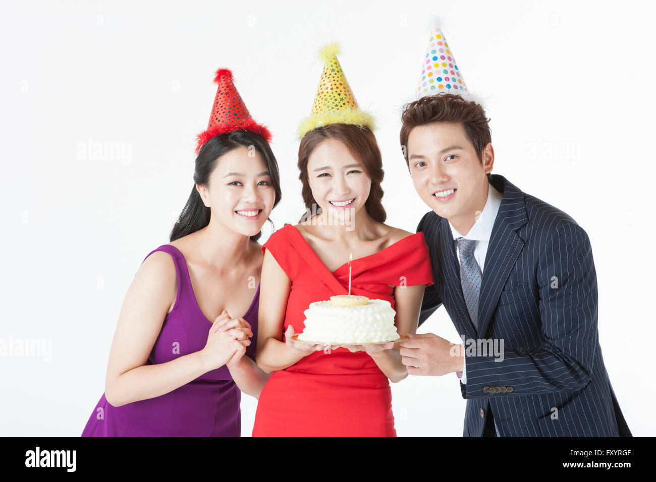 Portrait of three young people with a cake at party Stock Photo - Alamy