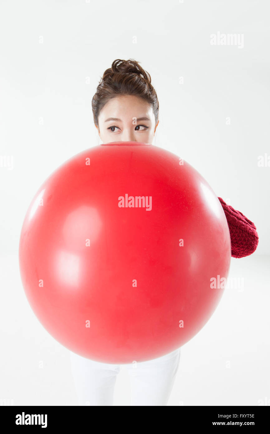 Portrait of young woman blowing a big balloon Stock Photo - Alamy