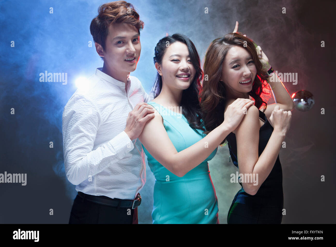 Side view portrait of three young smiling people posing staring at ...