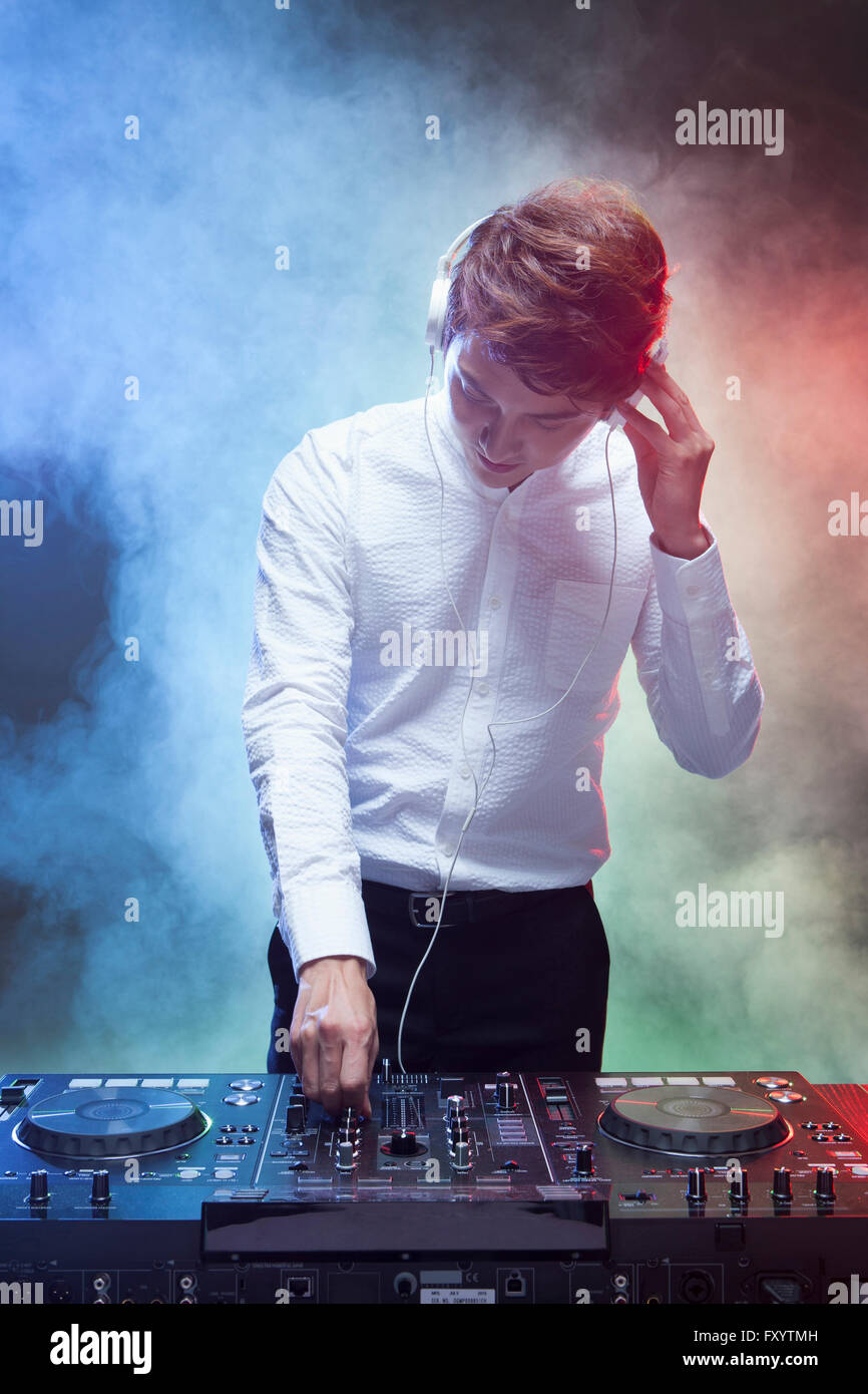 Young male DJ playing music at nightclub looking down Stock Photo - Alamy