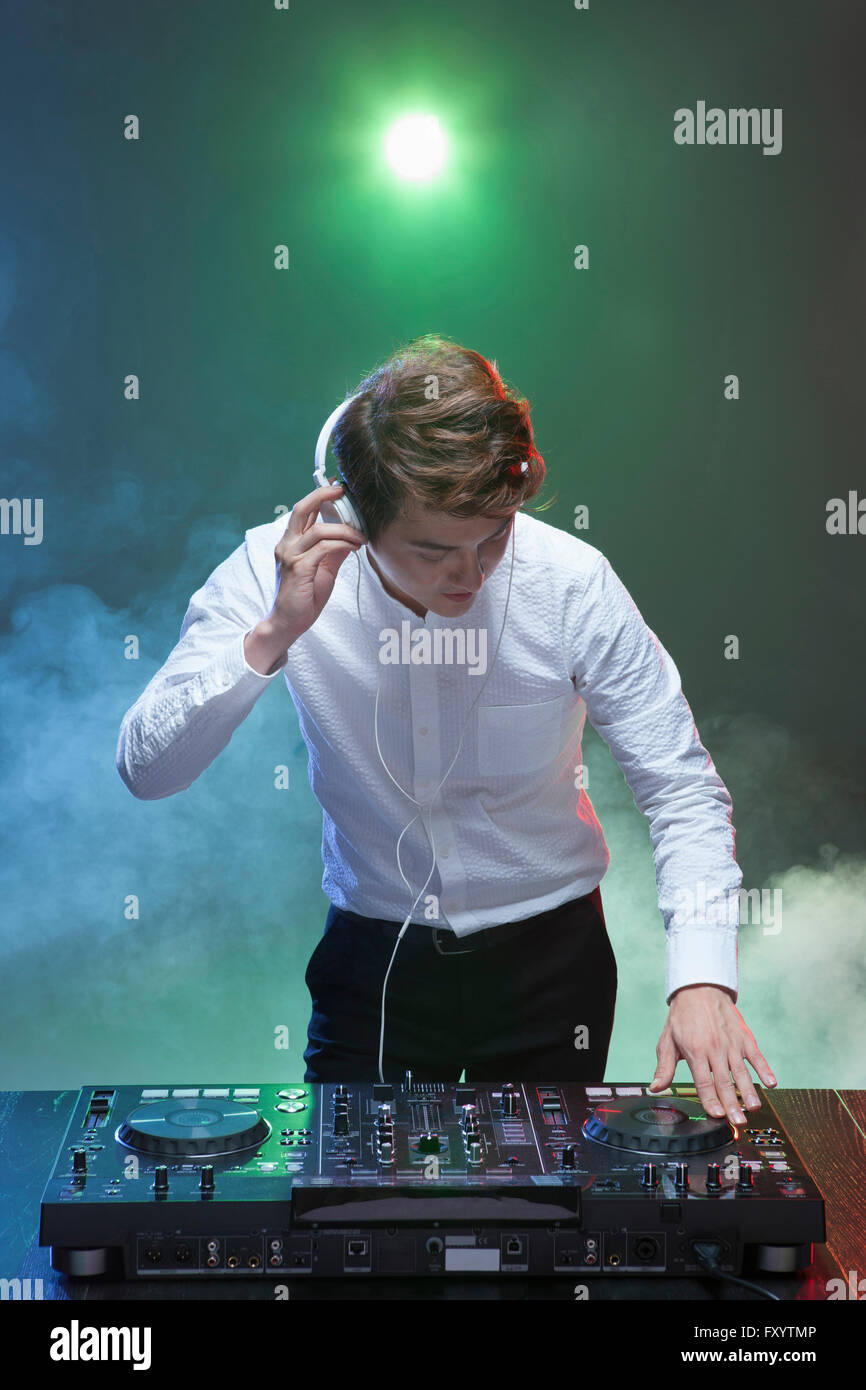Young male DJ playing music at nightclub looking down Stock Photo - Alamy