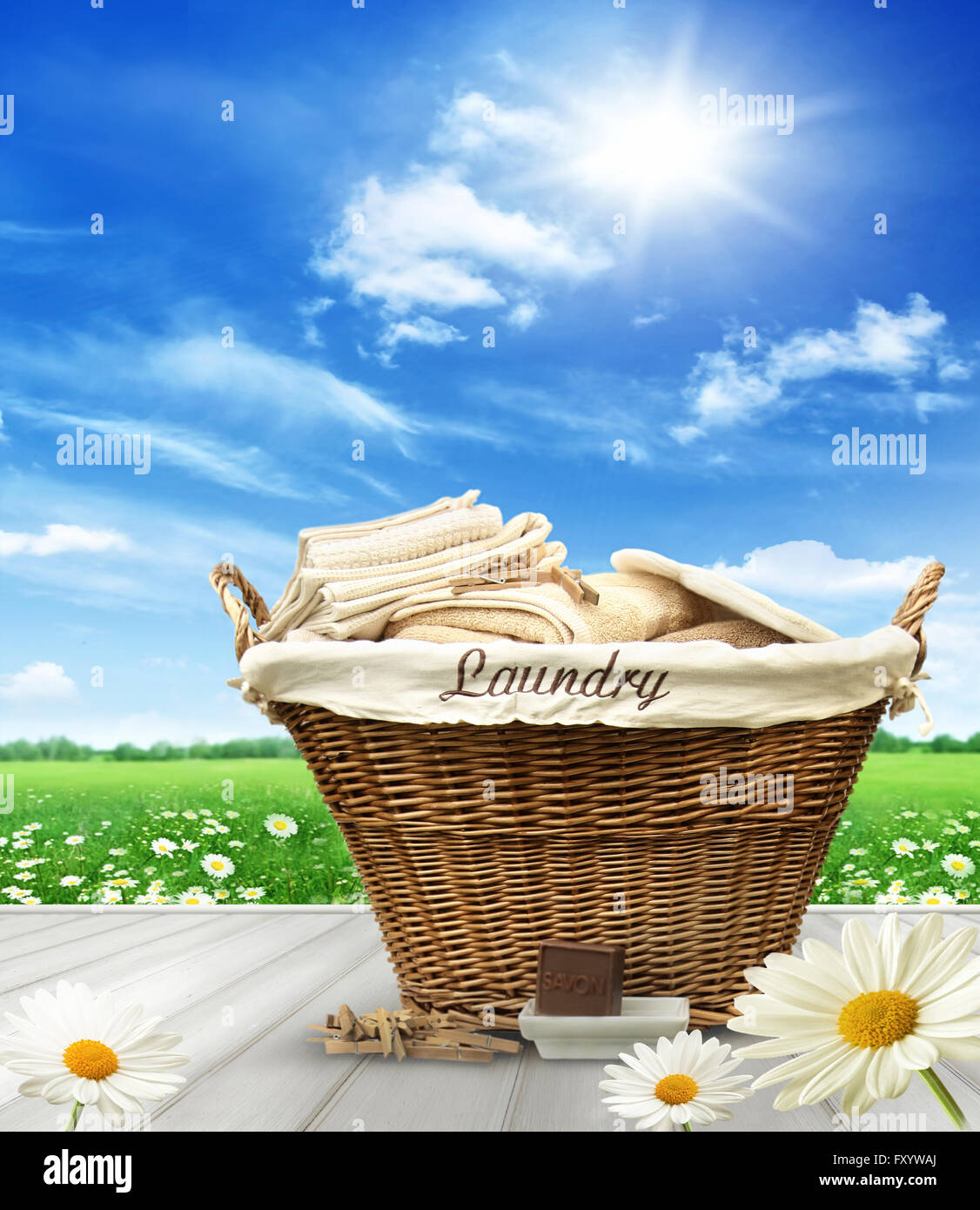 Laundry basket with clothes on rustic table against blue summer sky ...