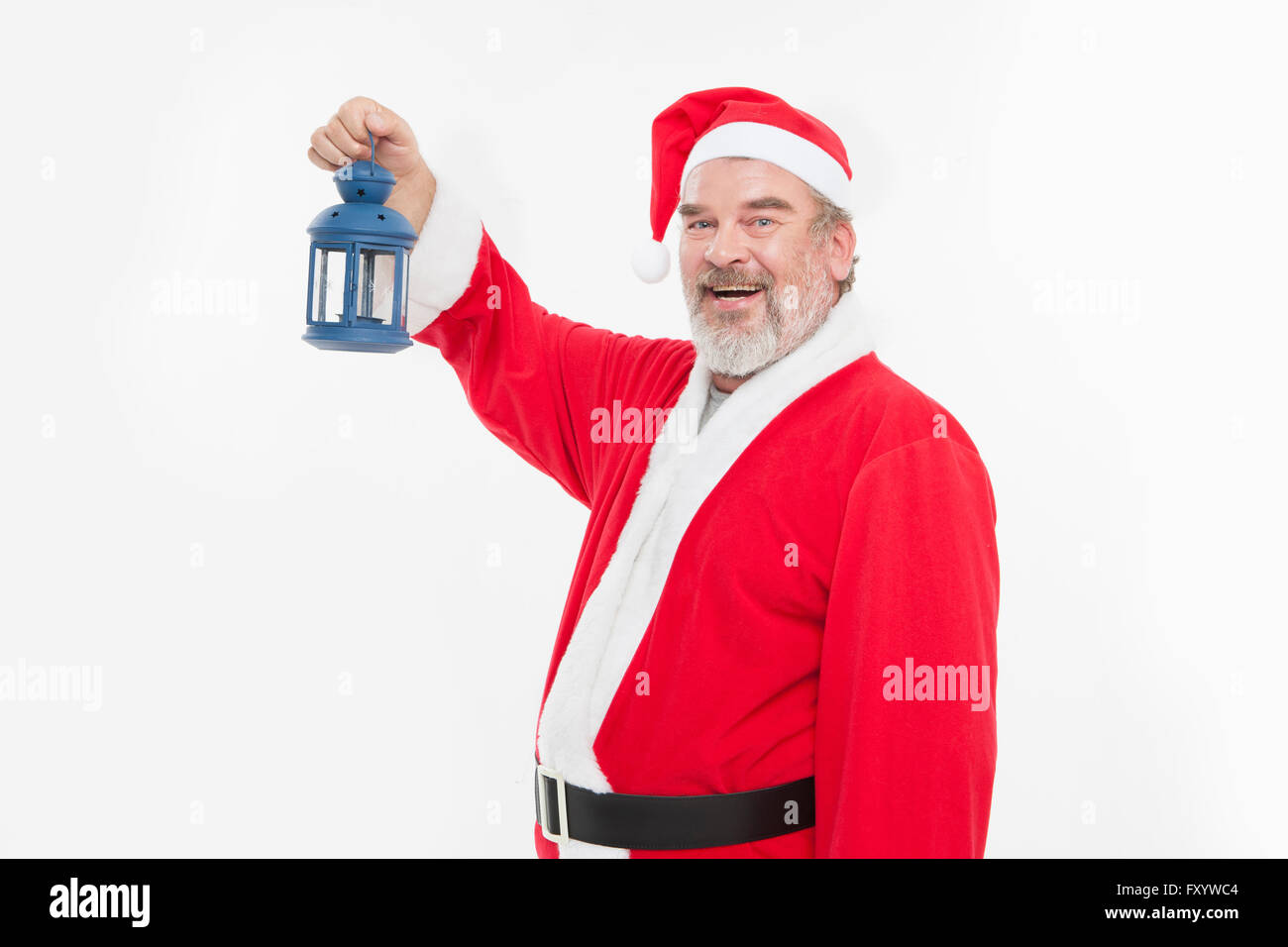 Side view portrait of smiling Santa holding a lantern staring at front ...