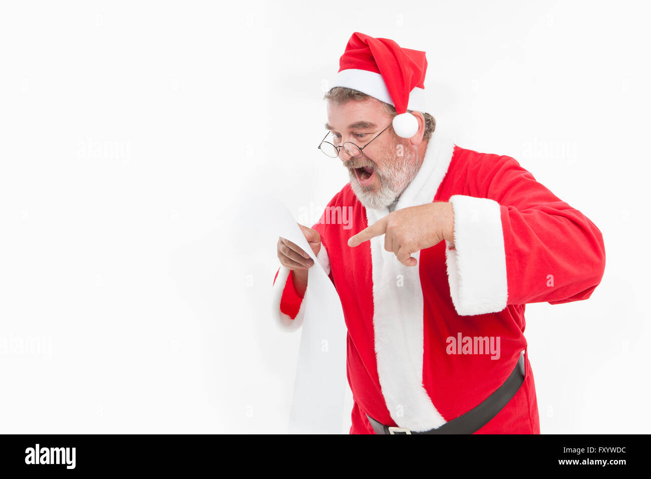 Side view portrait of Santa holding and looking down at a list with a ...