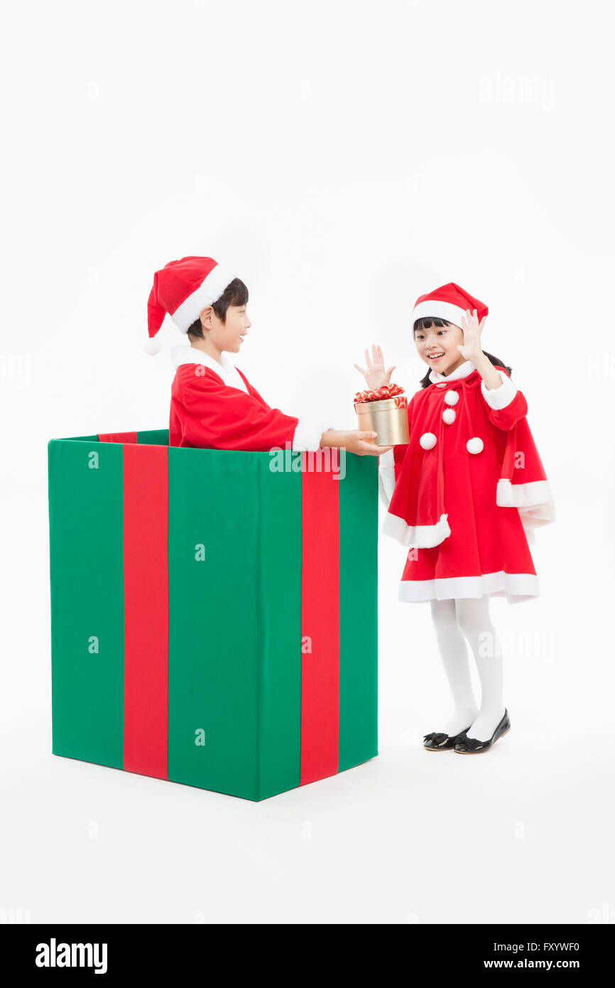 Side view portrait of boy in a big box giving a present box to a girl ...