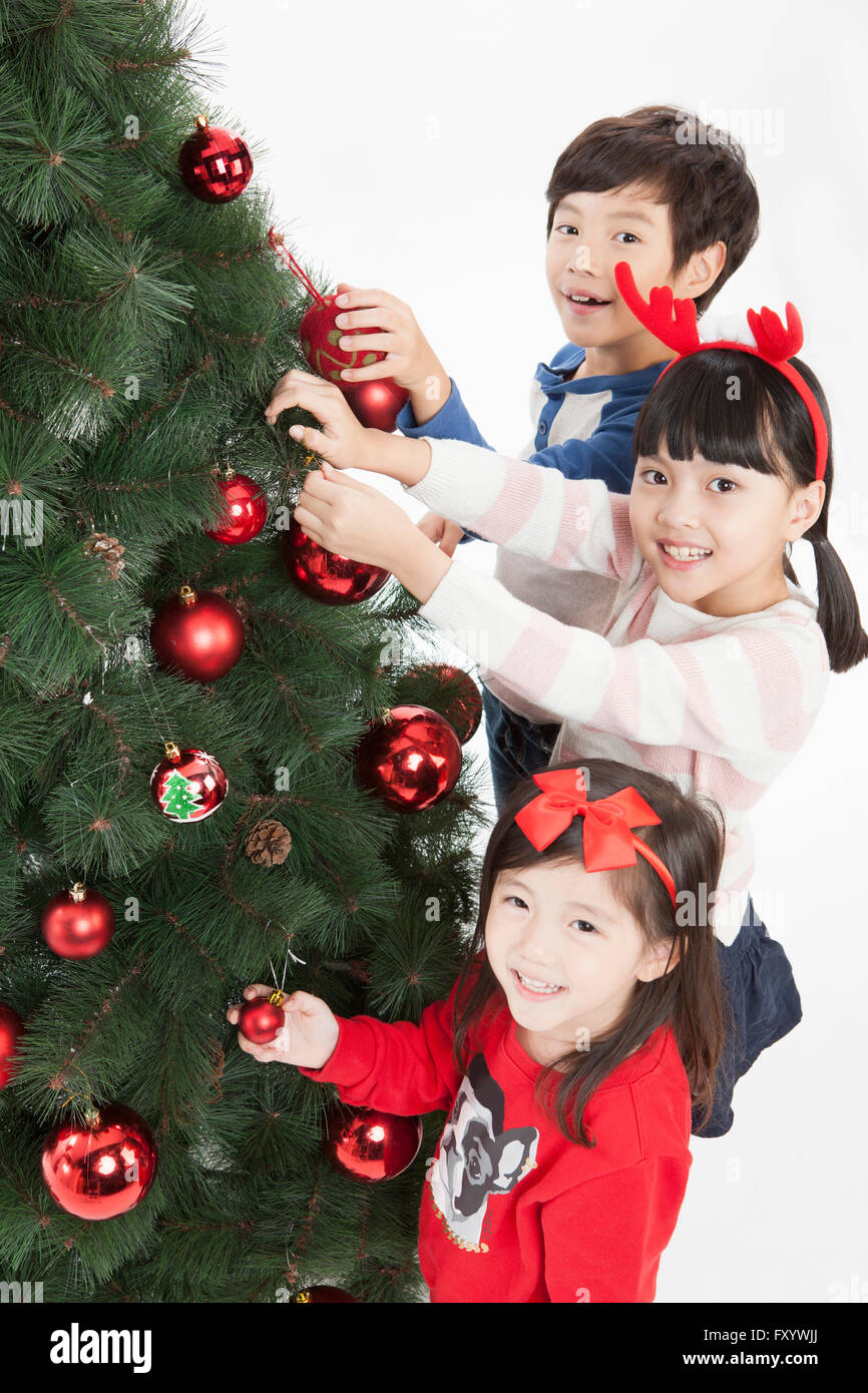 Three smiling children making Christmas tree staring at front Stock ...