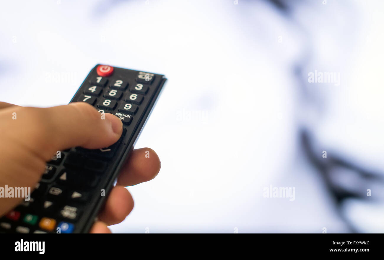 Male hand holding TV remote control Stock Photo - Alamy