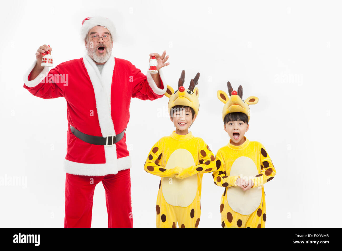 Santa holding bells in his both hands and children dressed like ...