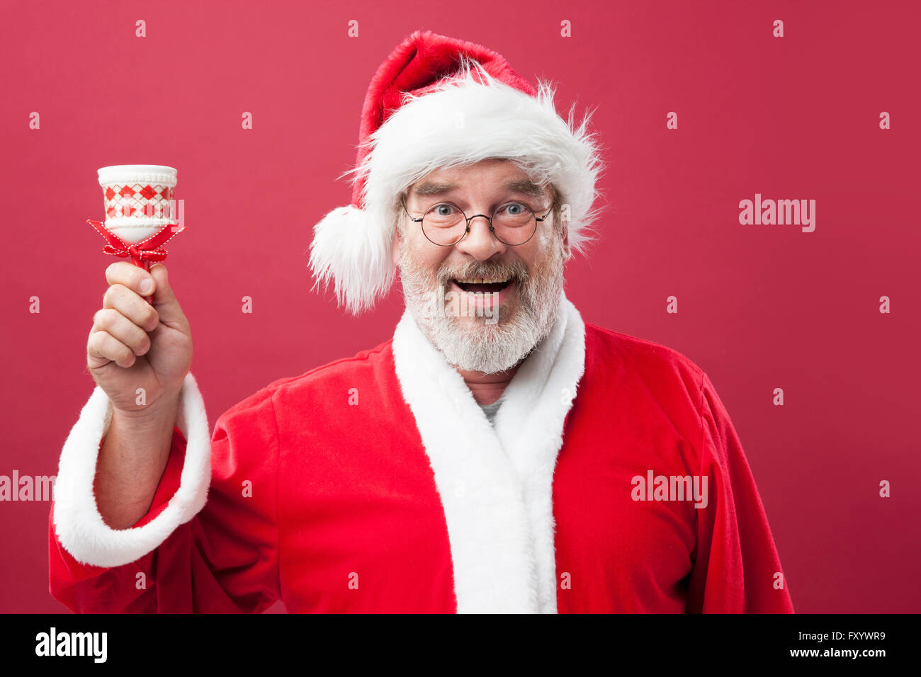 Portrait of smiling Santa holding a bell staring at front Stock Photo ...