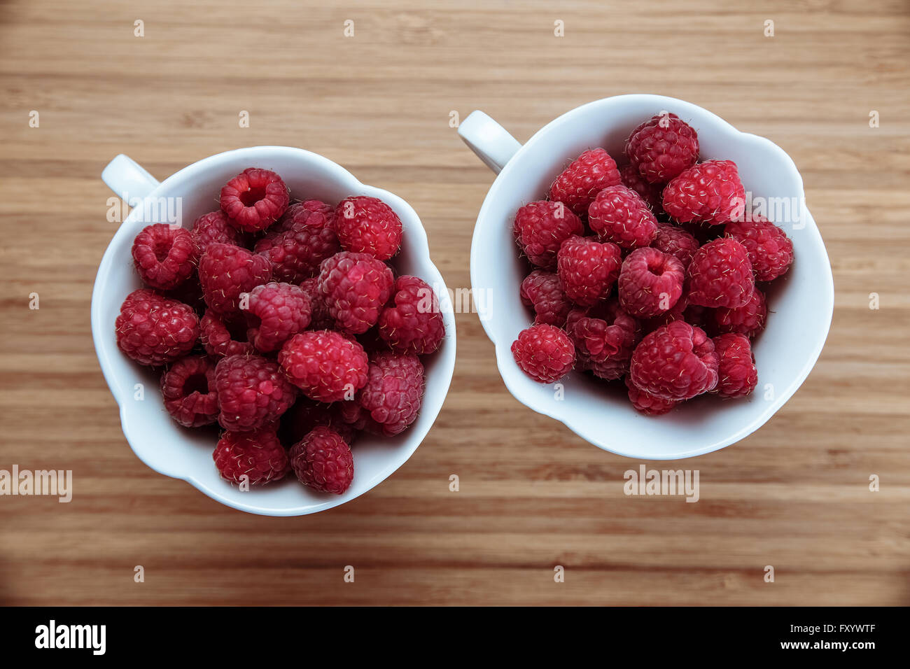 Many raspberries in white tea cups Stock Photo - Alamy