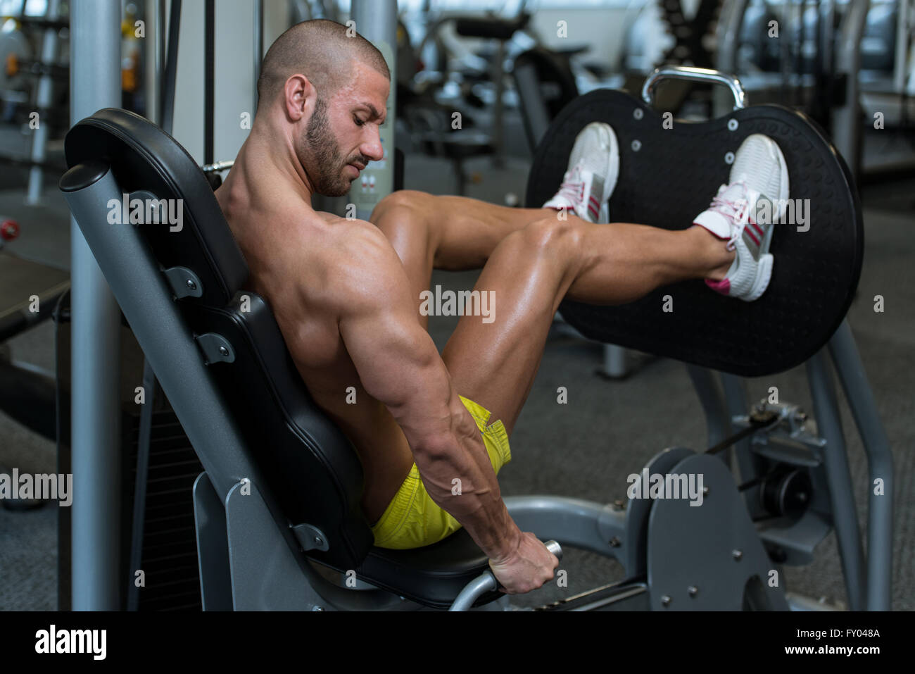 Attractive Young Man Doing Leg Press On Machine In Gym Stock Photo - Alamy