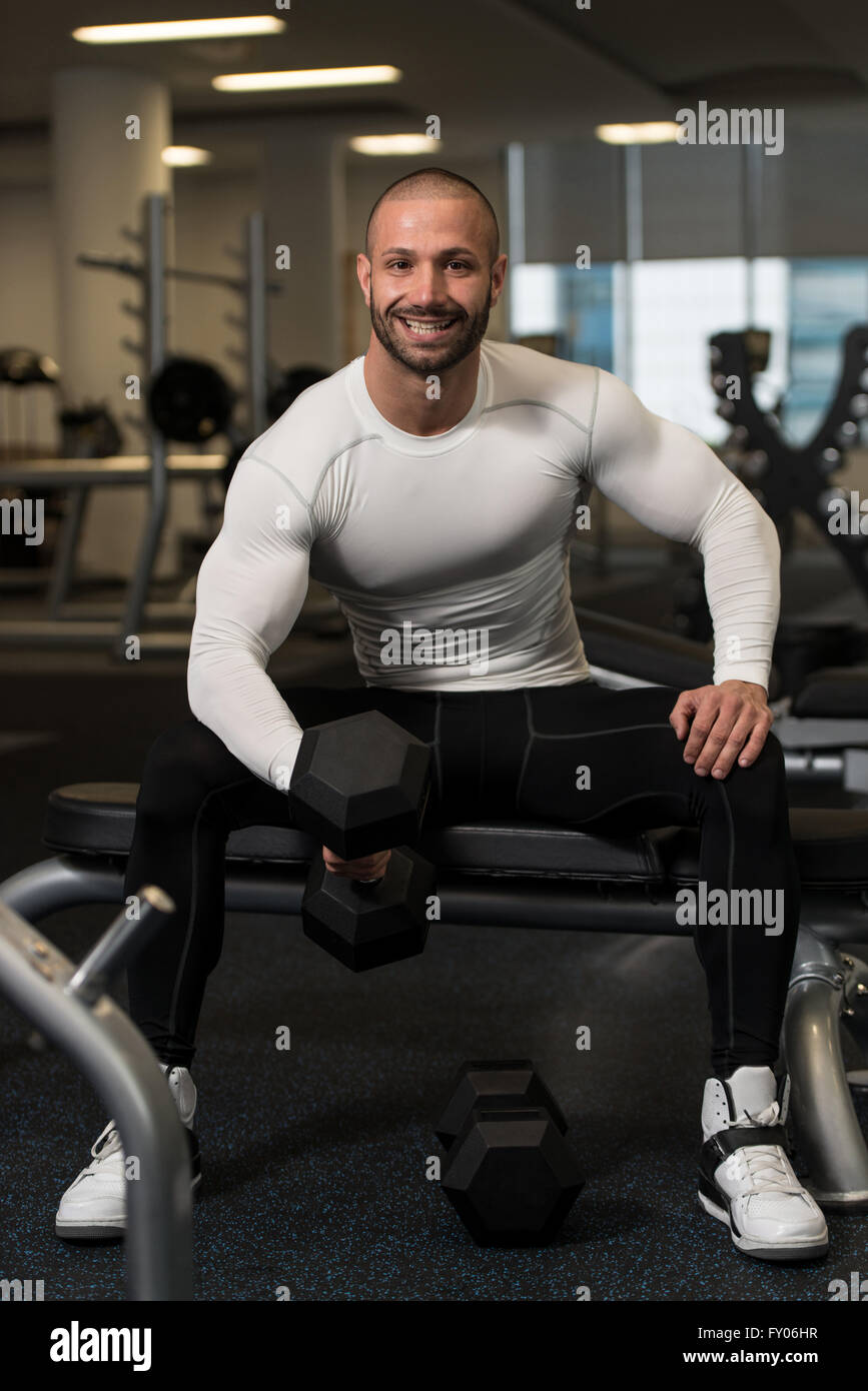 Young Healthy Man Working Out Biceps - Dumbbell Concentration Curls ...