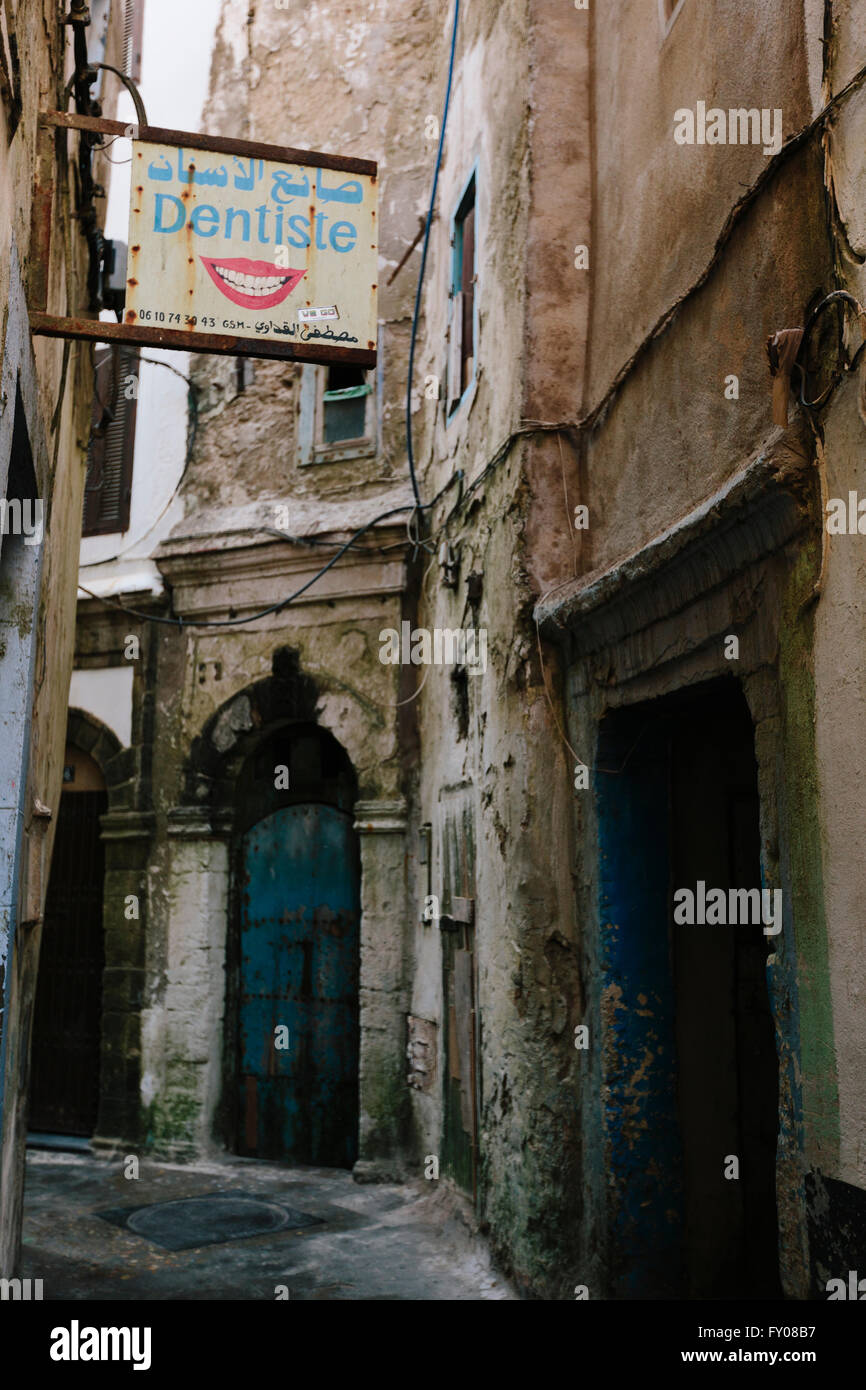 On a run down back alley in Essaouira, a rusty dentist sign hangs over ...