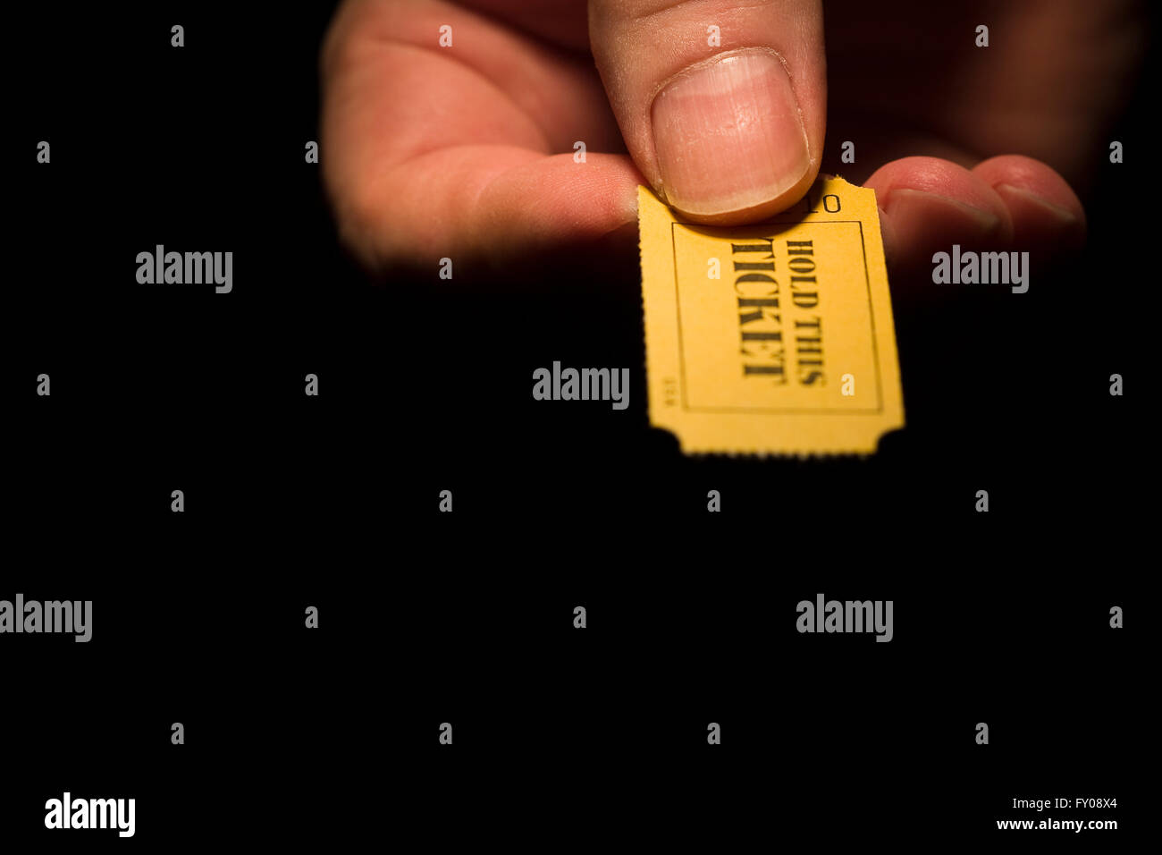 A man's right hand holding a yellow 7-digit ticket marked with the ...