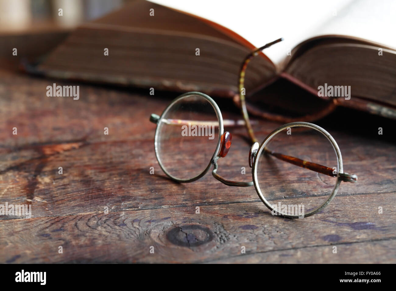 Still life with old spectacles near open book on wooden table Stock ...