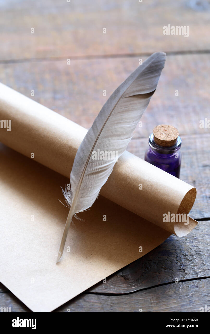 Writing concept. Closeup of scroll and quill near ink-pot on wooden ...