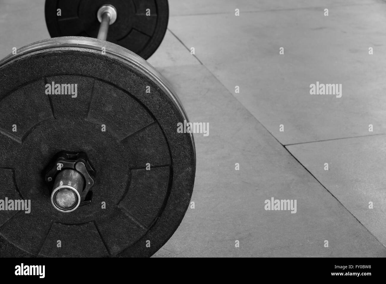 Barbell with weight plates on a gym floor, in black and white Stock ...