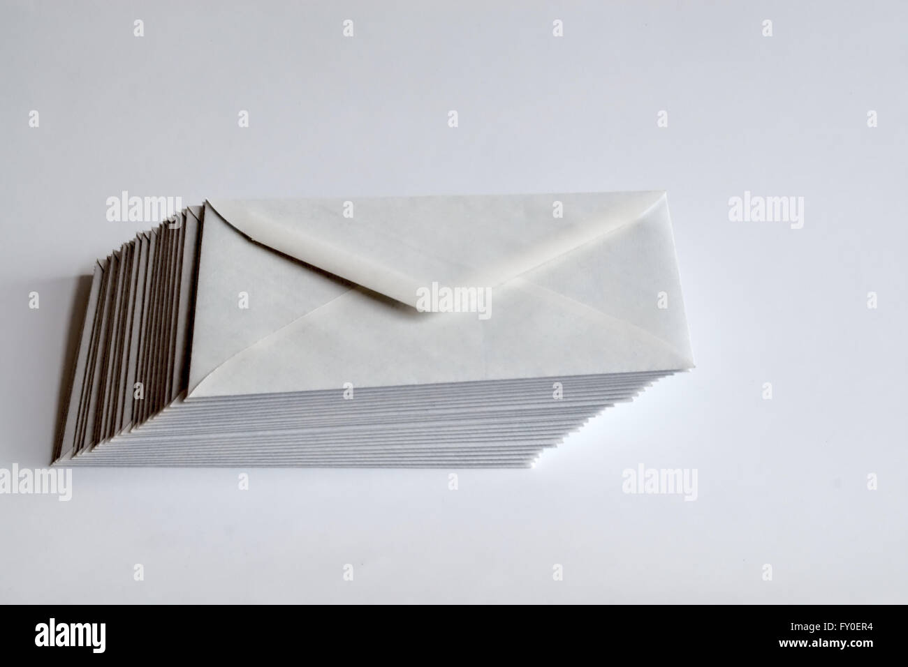Stack of plain white envelopes shifted to right on white background ...