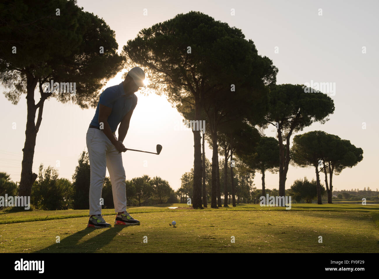 golf player hitting shot with club on course at beautiful morning with ...