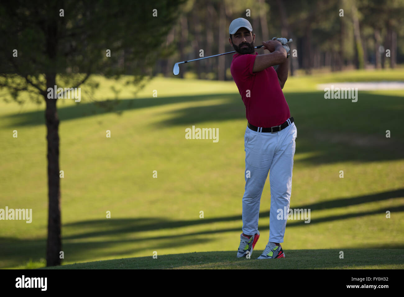 golf player hitting shot with driver on course at beautiful sunny day ...