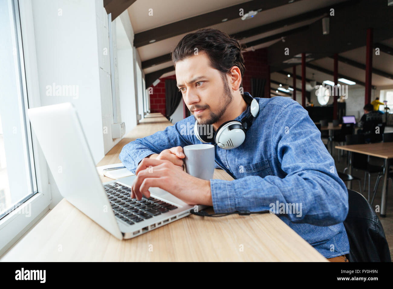 Handsome man using laptop computer in office Stock Photo - Alamy