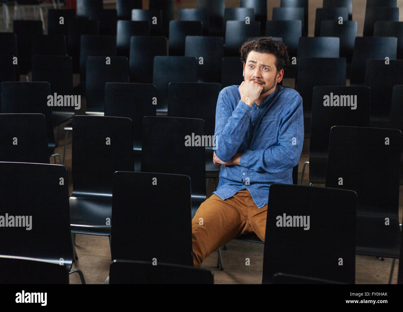 Scared man in casual cloth sitting in conference hall Stock Photo - Alamy