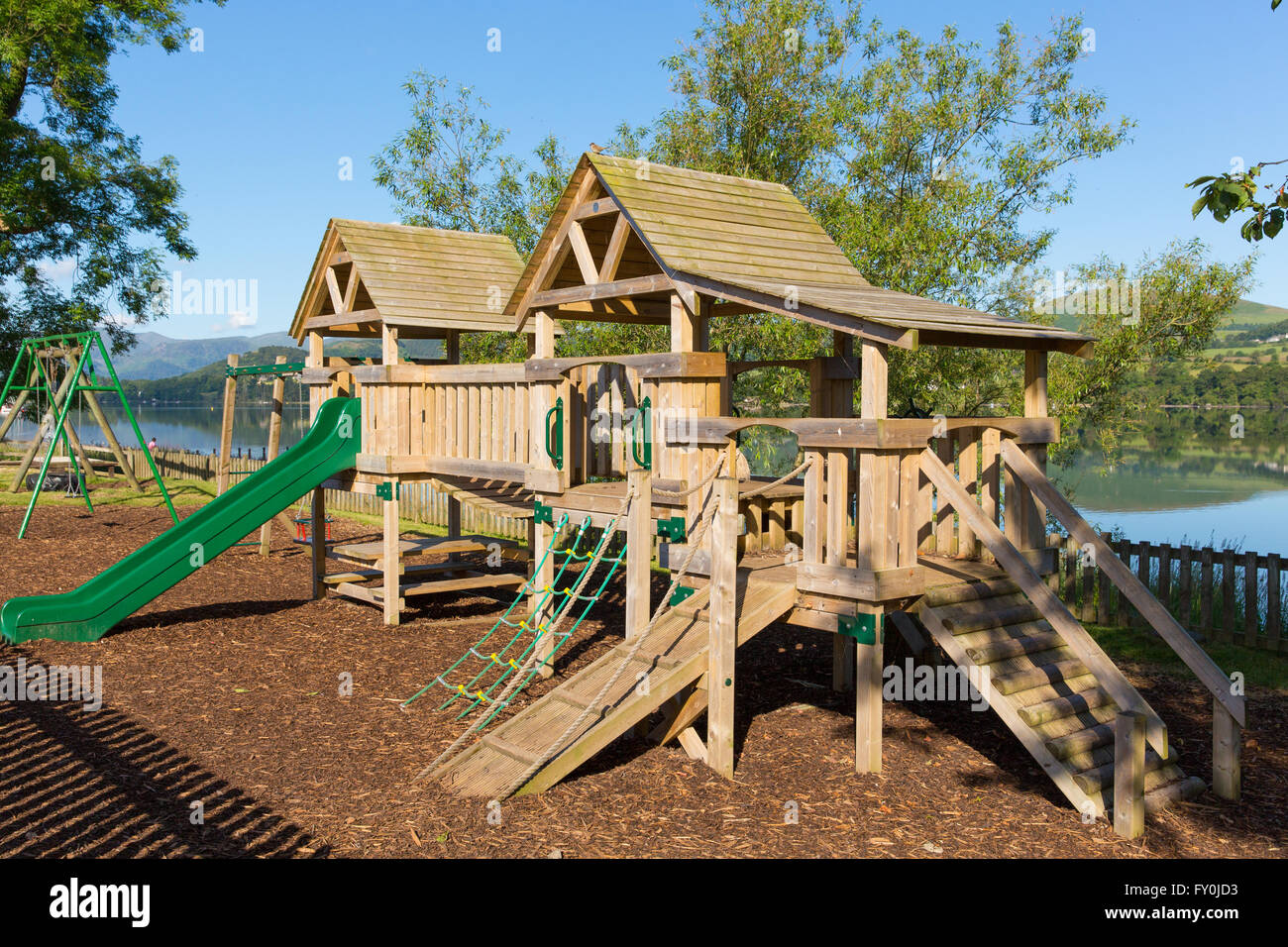 Wooden climbing frame for children in rural outdoor location by a lake ...