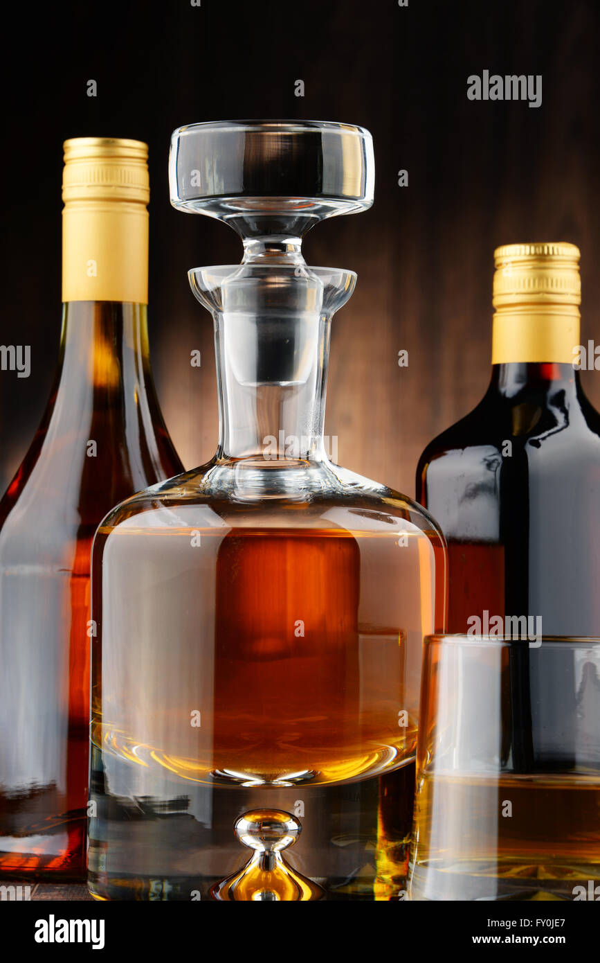 Composition with bottles of assorted alcoholic beverages and glass of ...