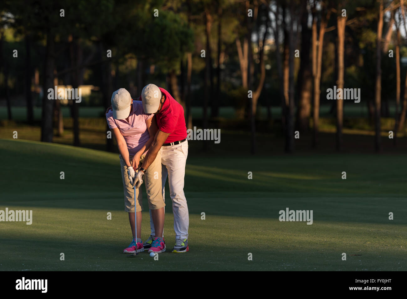Male golf instructor teaching female golf player hi-res stock ...