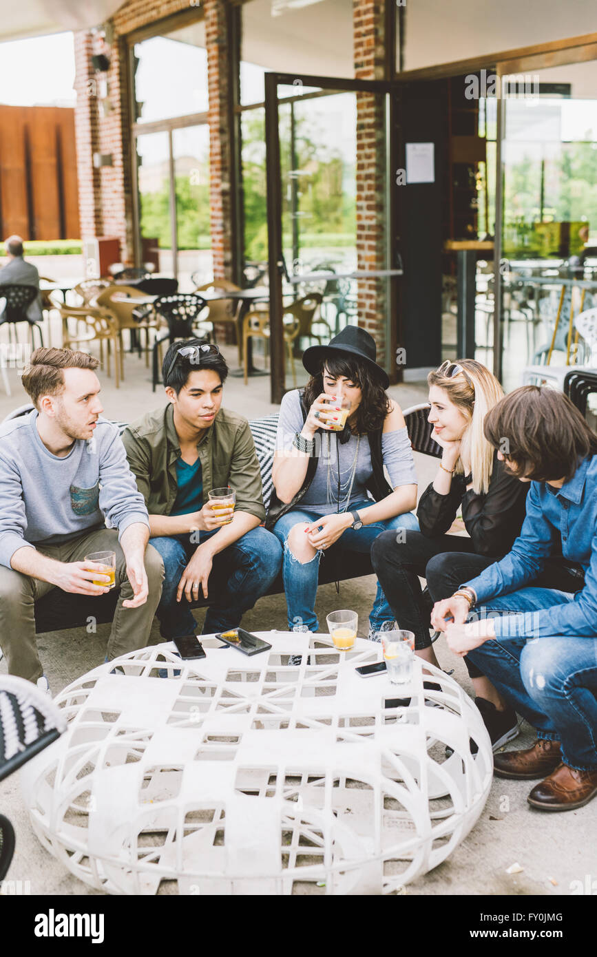 Group of young multiethnic friends sitting in a bar having a drink ...