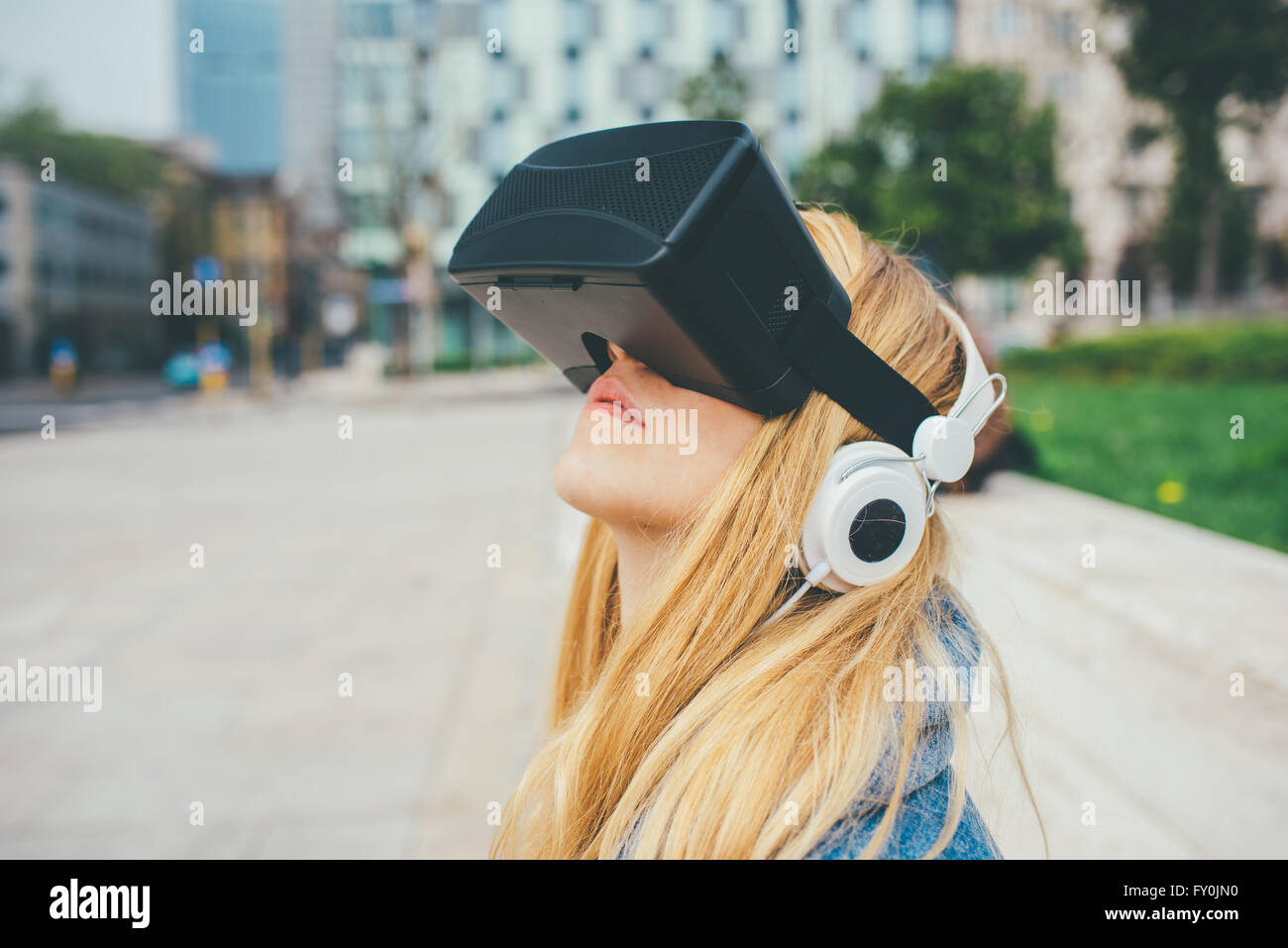 Young beautiful blonde caucasian woman sitting using 3D viewer looking ...