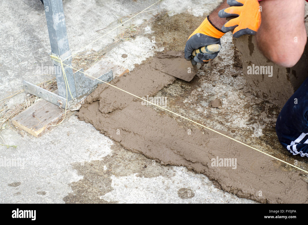 Bricklayer working with mud bricks for building a wall. Construction ...