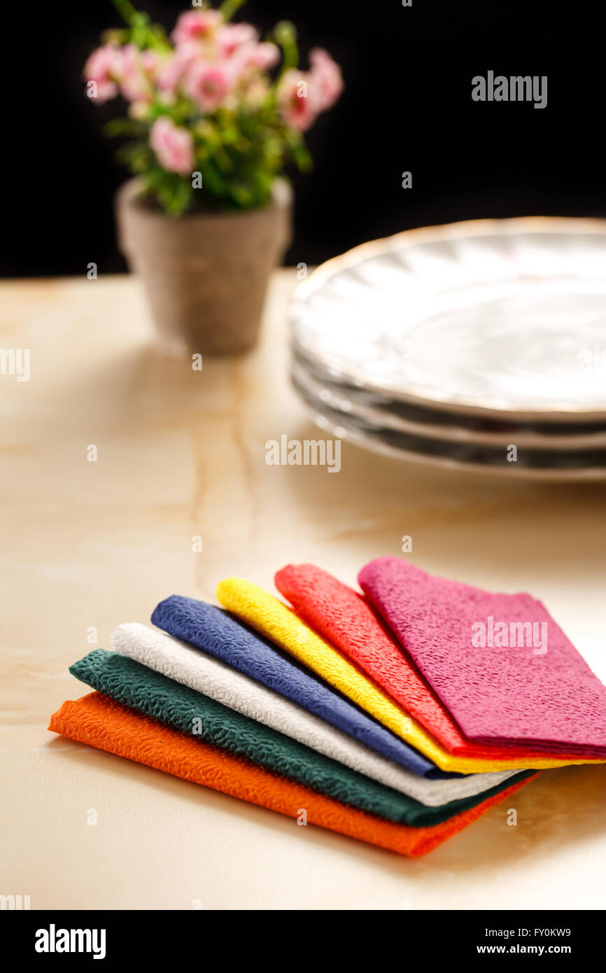 Still life with colorful paper table napkins, flowers and plates Stock ...