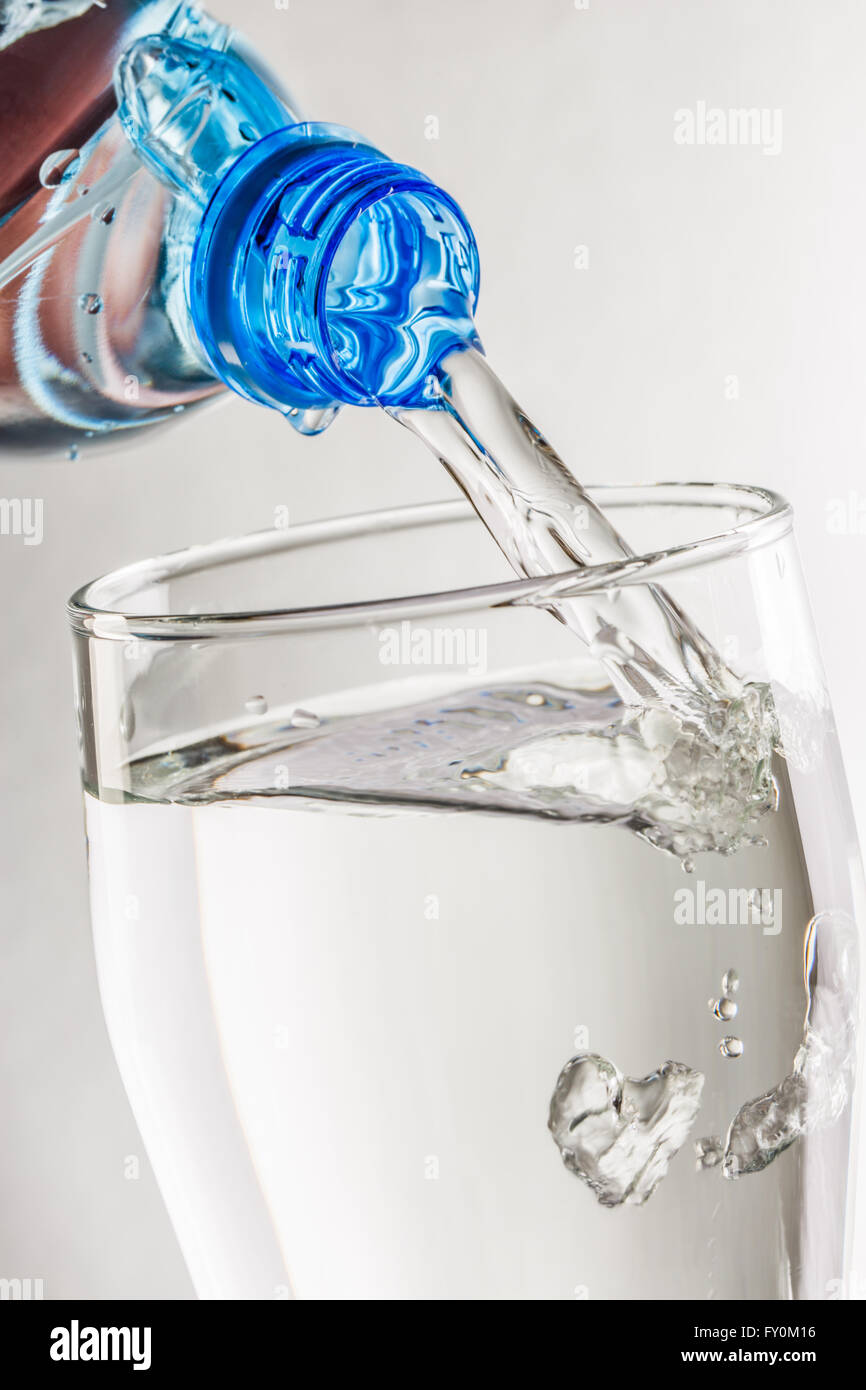 Pouring water from bottle into glass Stock Photo - Alamy
